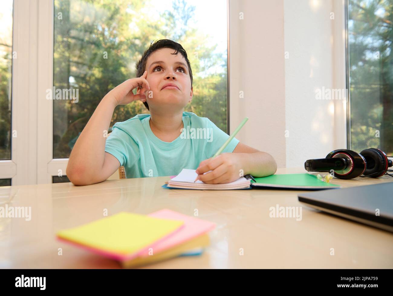 Handsome Caucasian child smart schoolboy thoughtfully looking up while ...