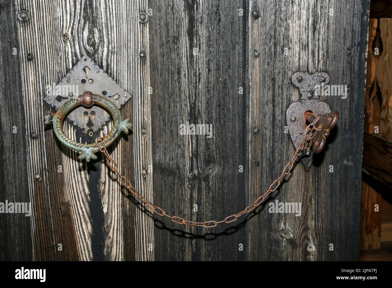 Close up historic door key in keyhole with a chain, Grafarkirkja turf ...