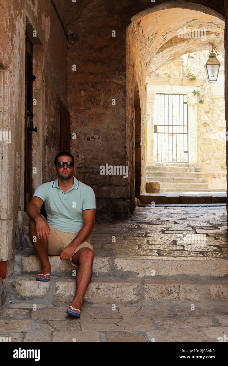 Narrow street in the Old Town of Dubrovnik, Croatia. A handsome young ...