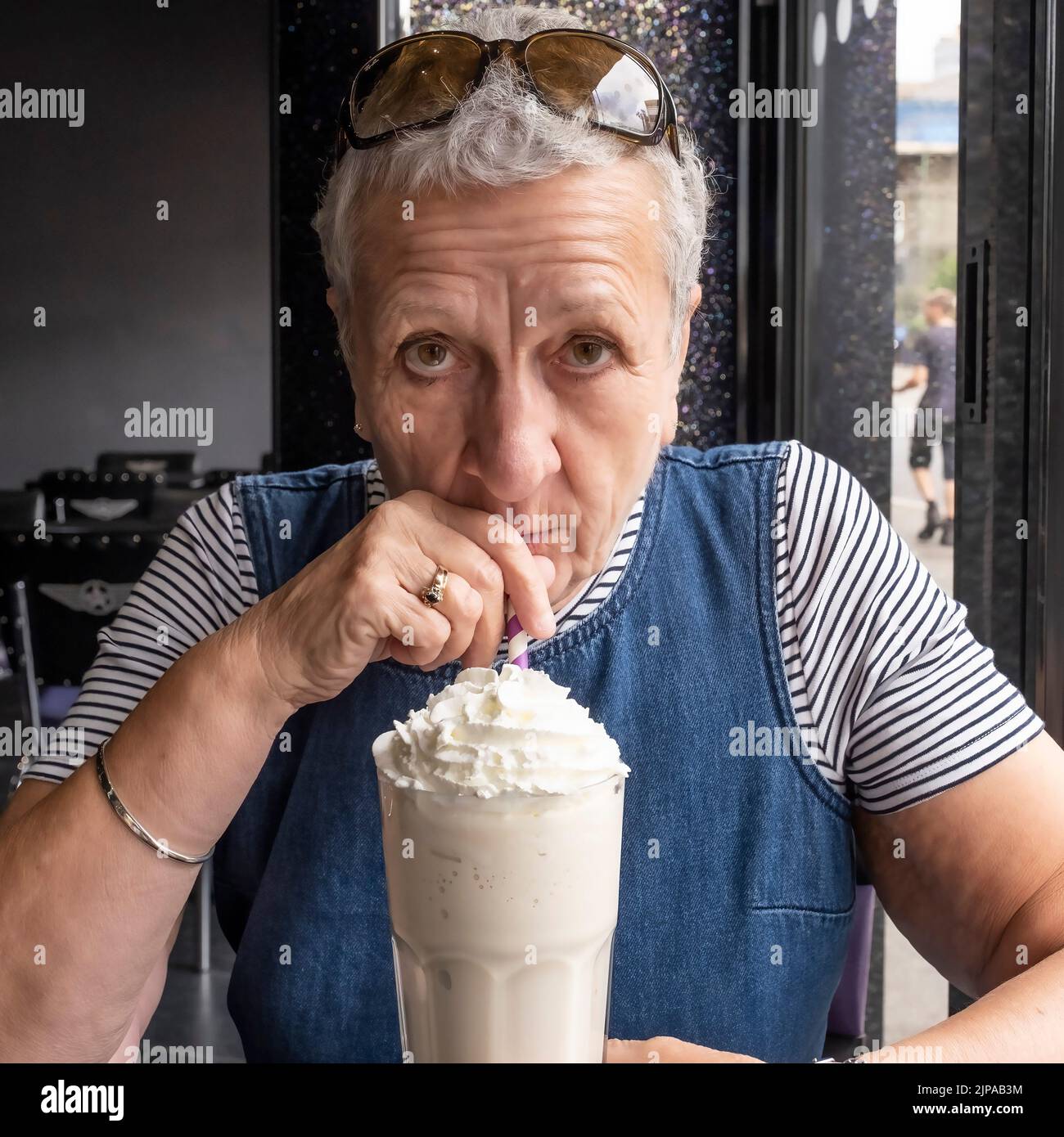 A mature lady enjoying a milk shake in a cafe Stock Photo - Alamy