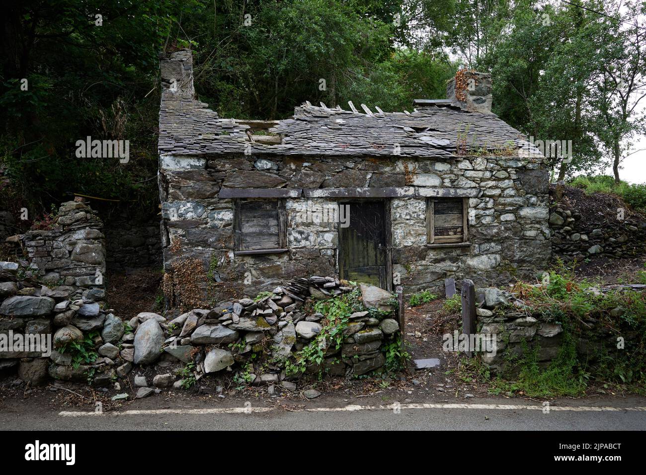 A derelict Welsh stone and slate roof cottage in the village of ...