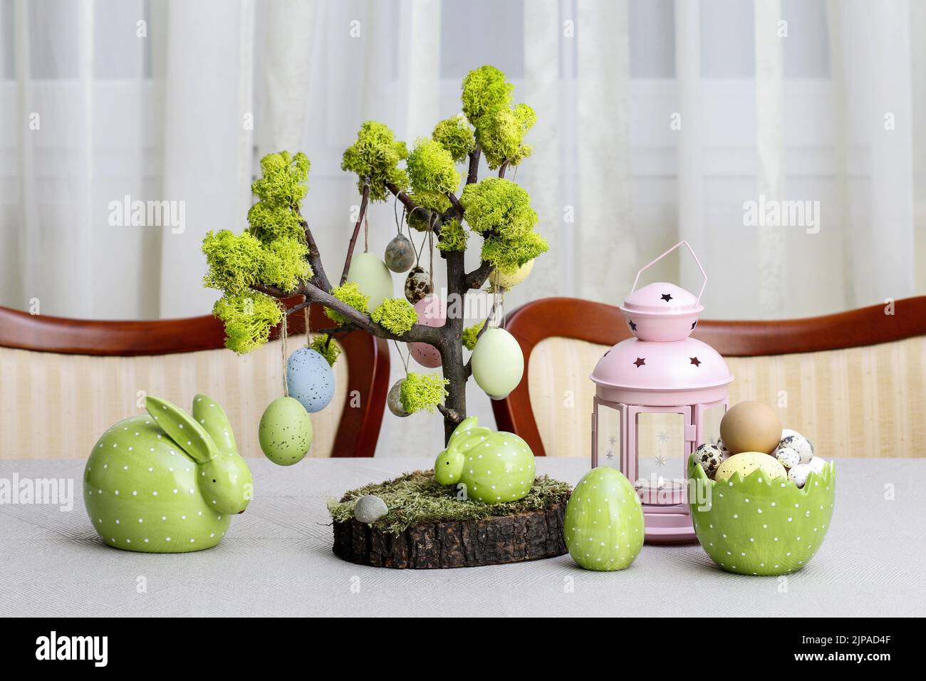 Easter decoration in tree shape with hanging eggs. Ceramic figurines ...
