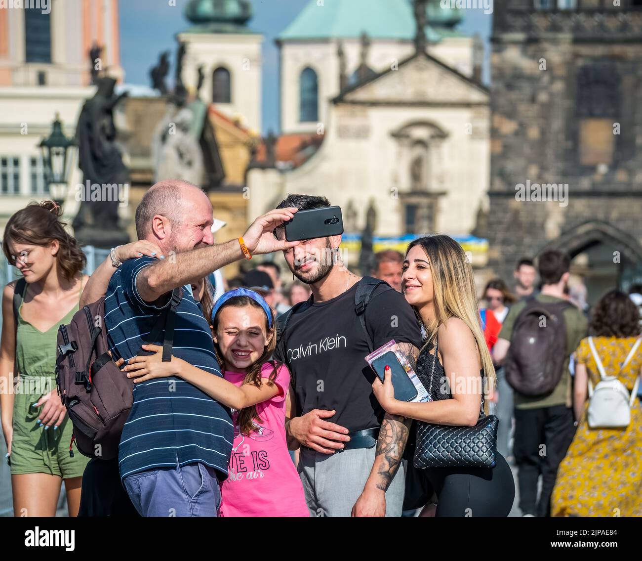 Prague, Czech Republic - June 2022: Happy tourists strolling and taking ...