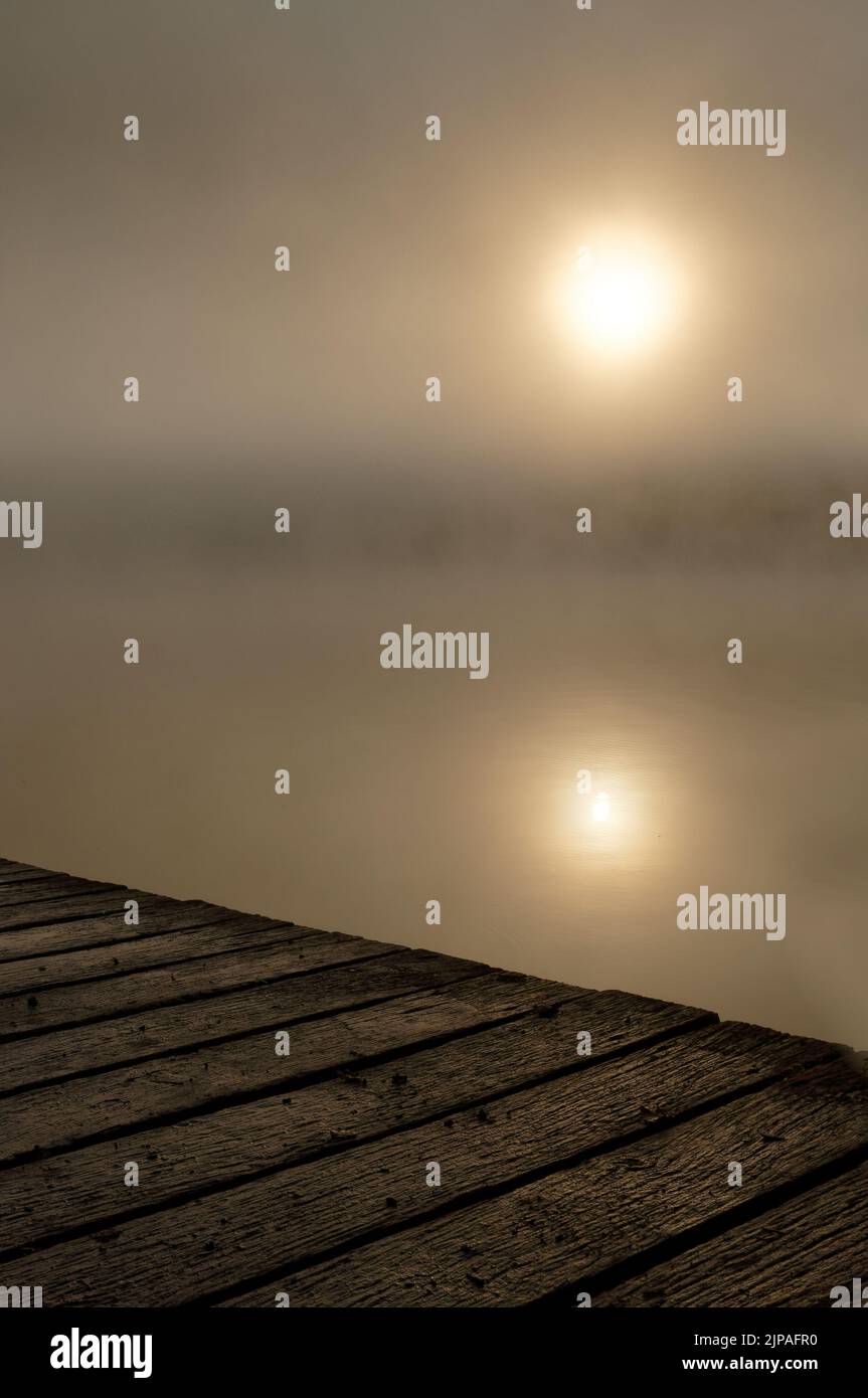 A moody scenic landscape of a sunrise over a foggy lake Stock Photo - Alamy