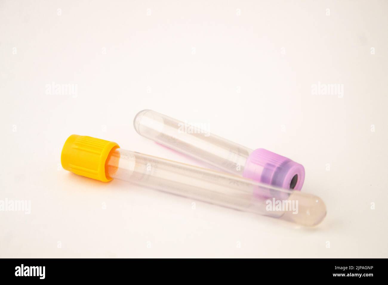 Yellow, purple colored blood test tubes on the isolated white ...