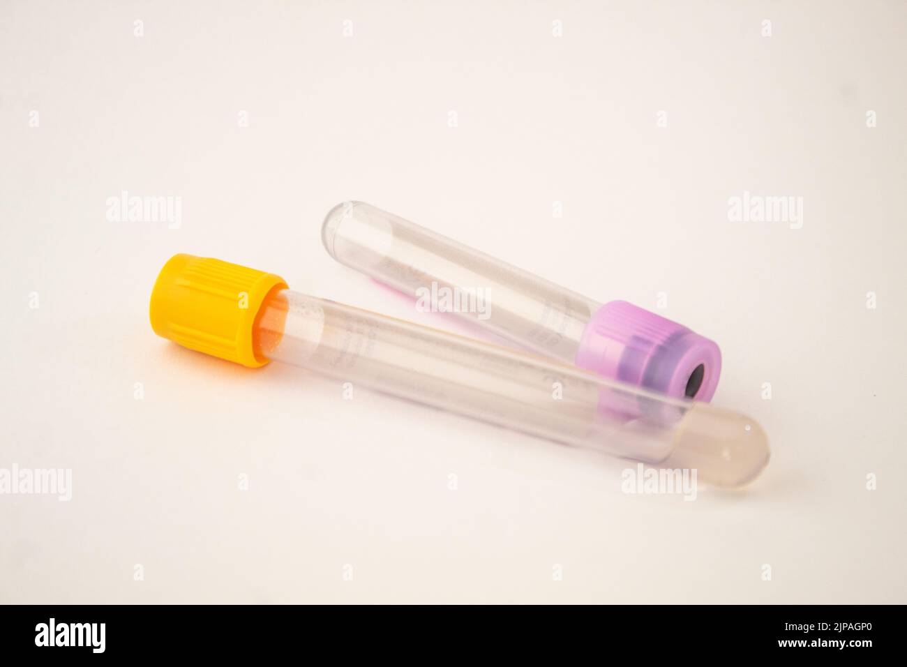 Yellow, purple colored blood test tubes on the isolated white ...