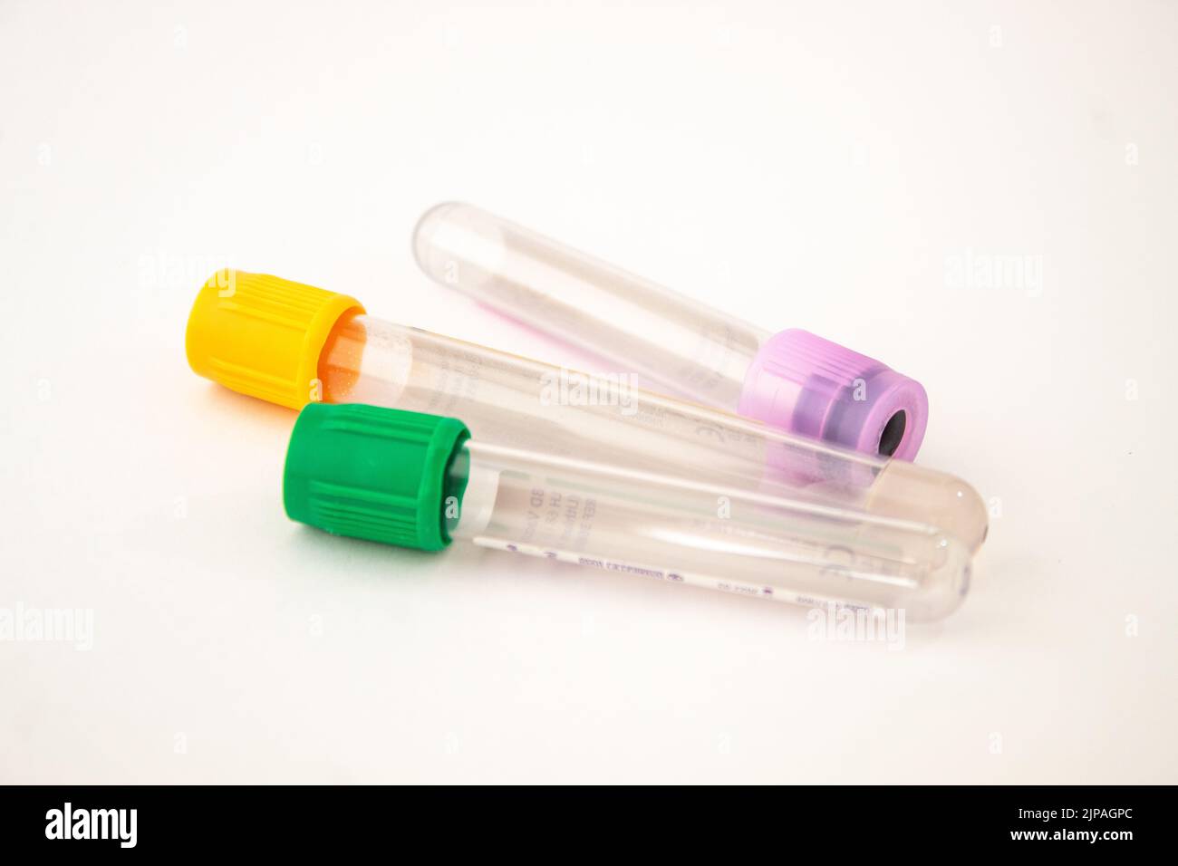 Yellow, green, purple colored blood test tubes on the isolated white ...