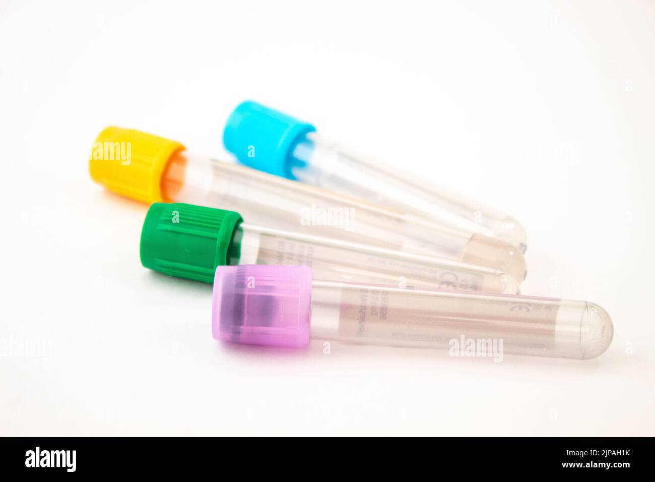 Yellow, green, purple, blue colored blood test tubes on the isolated ...