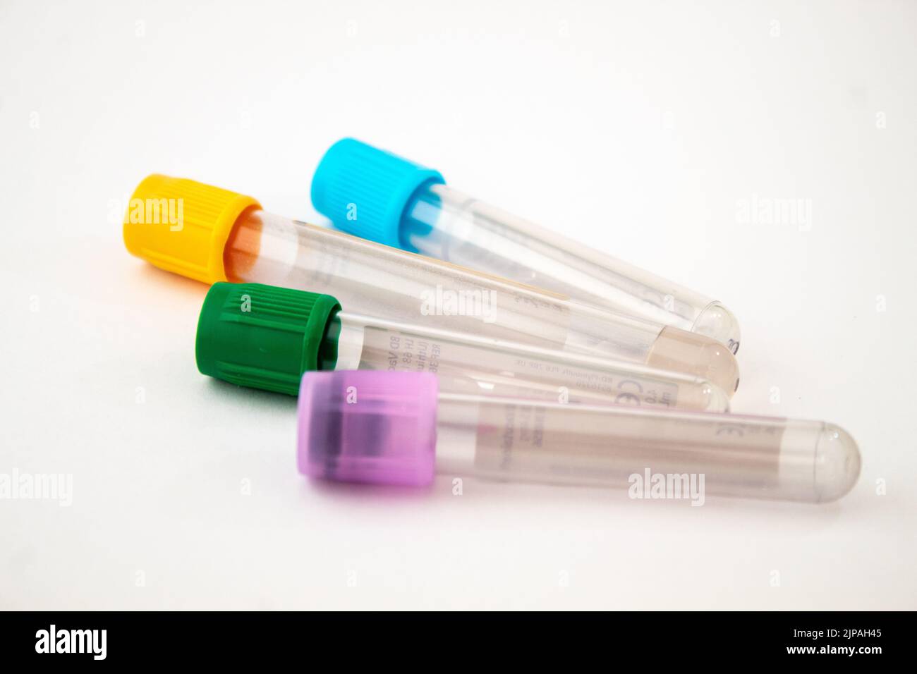 Yellow, green, purple, blue colored blood test tubes on the isolated ...