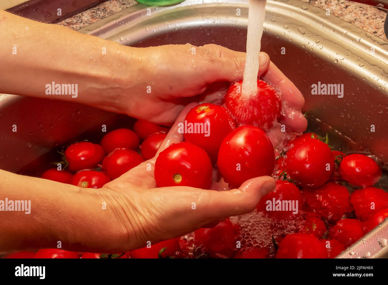 The woman's hands wash the tomatoes and remove the stalks from the ...