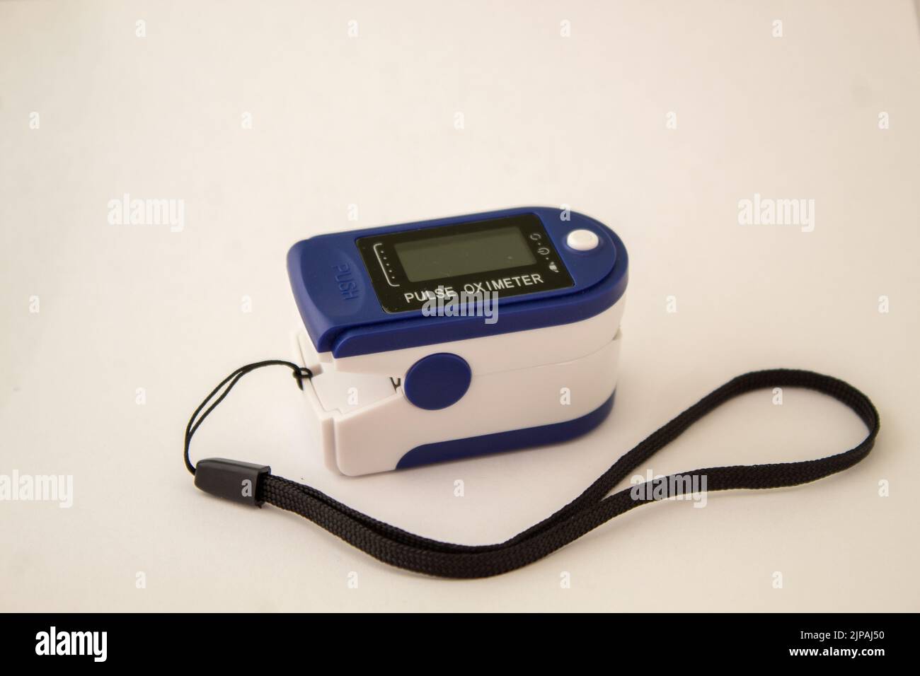 A blue pulse oximeter on the isolated white background Stock Photo - Alamy