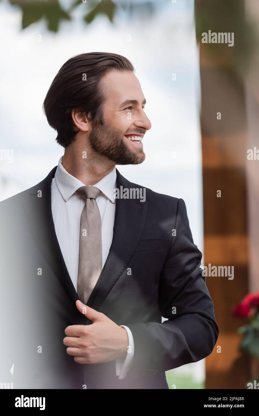 Side view of positive bearded groom in suit looking away outdoors Stock ...