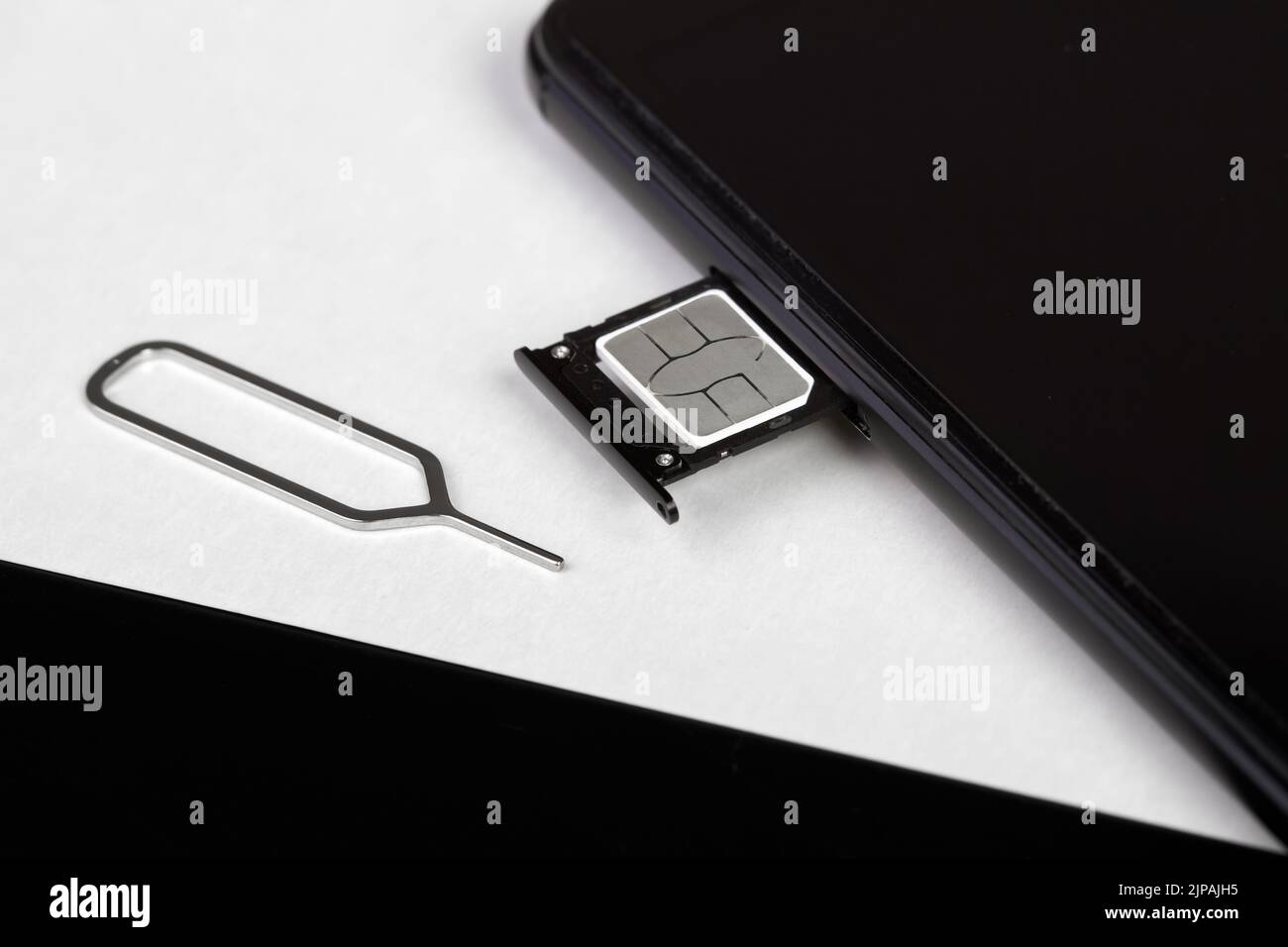 SIM card inserted into the sim card tray of a smartphone with pin ...