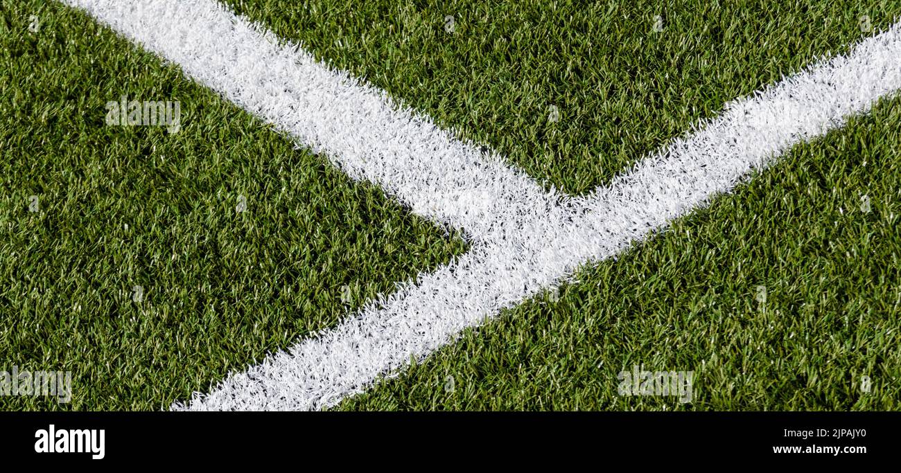 Green synthetic artificial grass soccer sports field with white corner ...