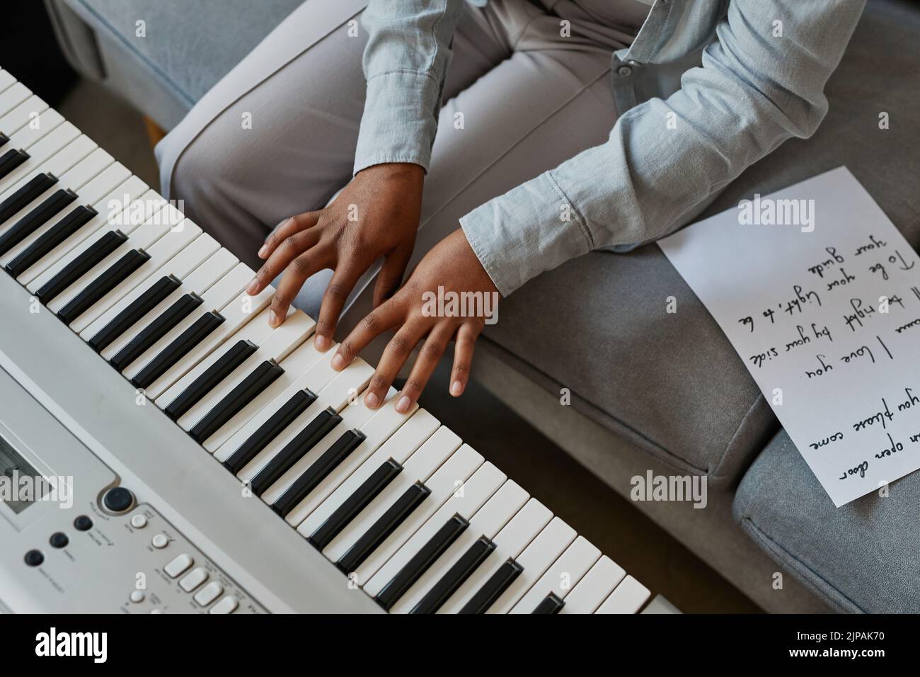 Top view close up of young woman pressing piano keys while composing ...