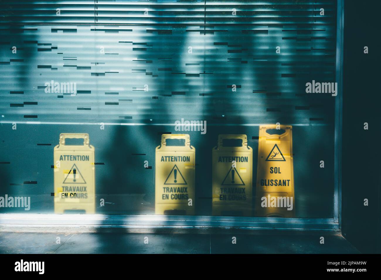 Four danger signs saying slippery floor and work in progress in an ...