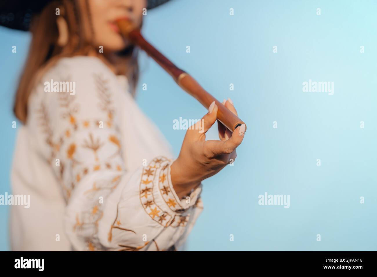 Woman playing on woodwind wooden flute - ukrainian telenka or tylynka ...