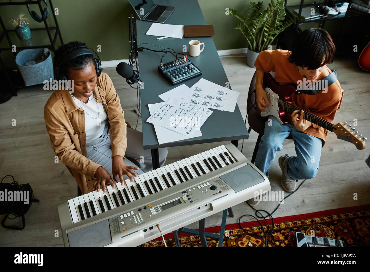 Top view at two young musicians playing instruments together in cozy ...
