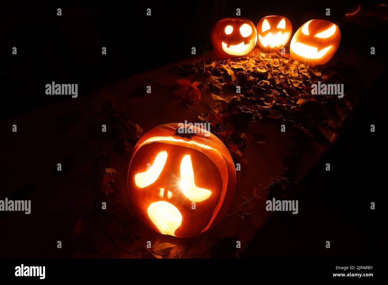 Scary Halloween pumpkins with eyes glowing inside at black background ...