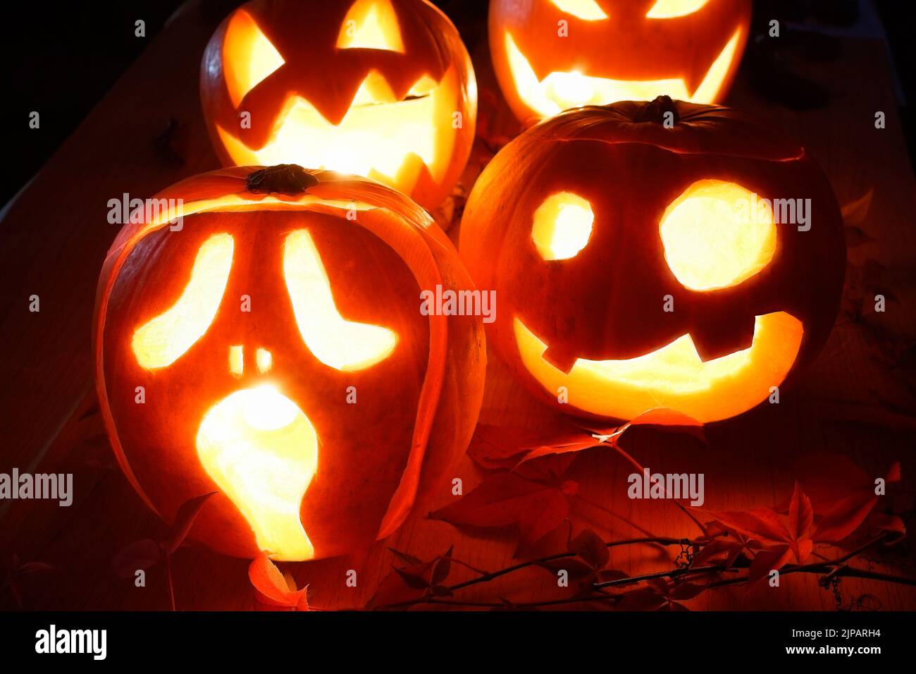 Scary Halloween pumpkins with eyes glowing inside at black background ...