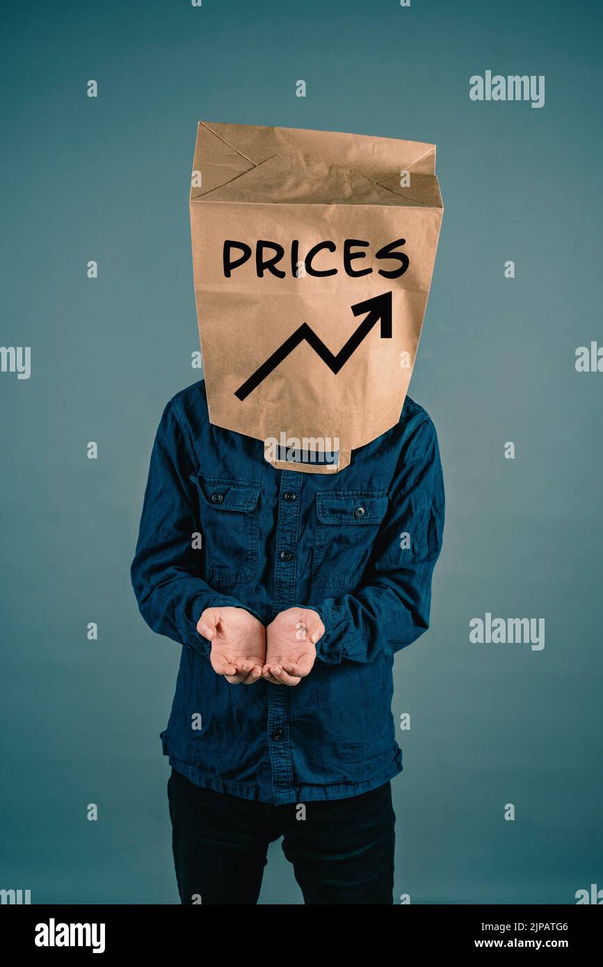 Young man with paper bag on his head, increasing prices, open hands ...