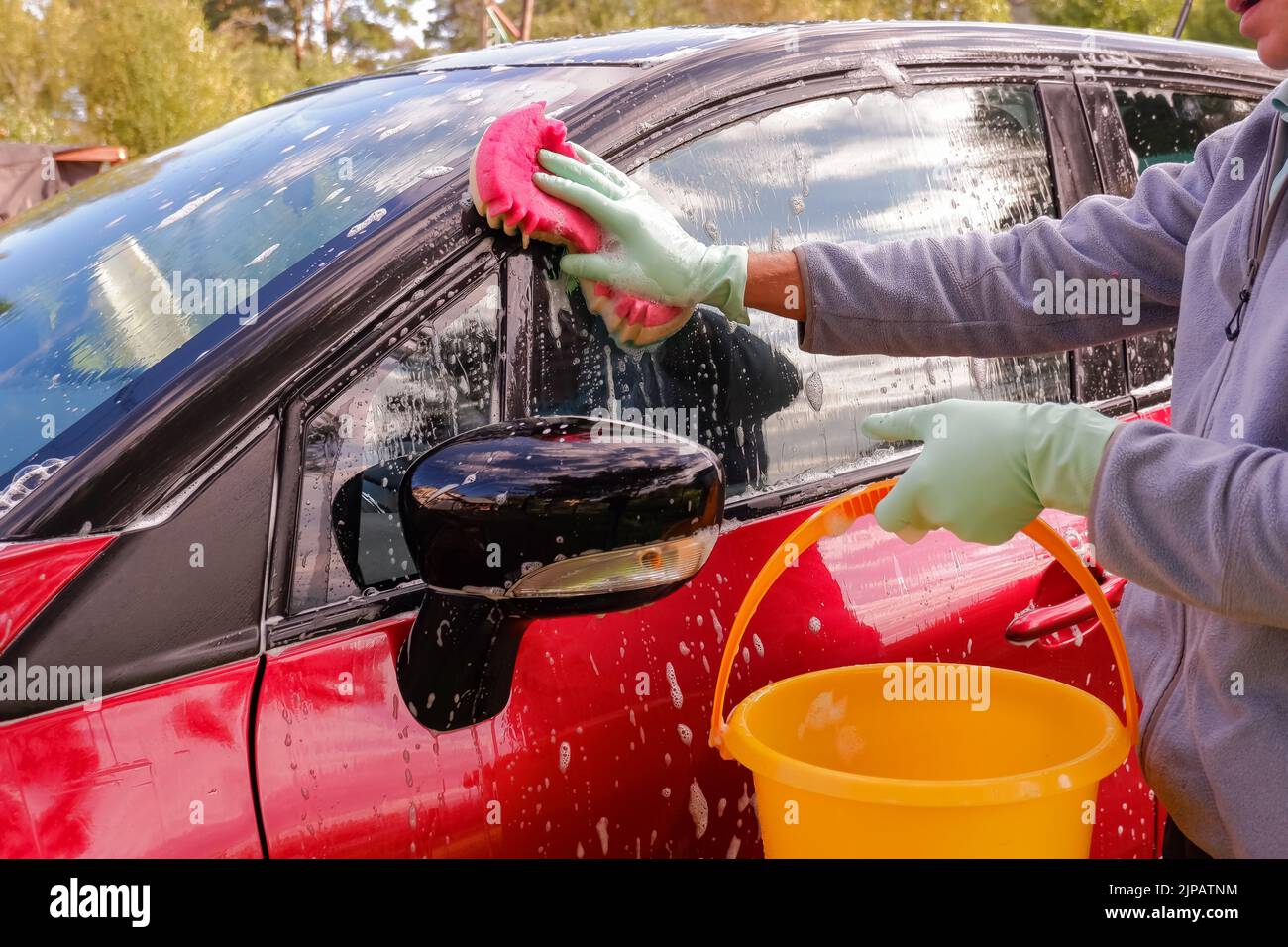 Worker washing red car with sponge on a car wash Stock Photo - Alamy