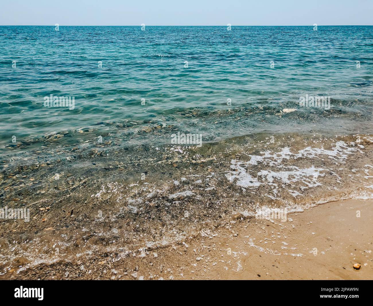 Close up sea waves stones shells beach summer day. top view above ...