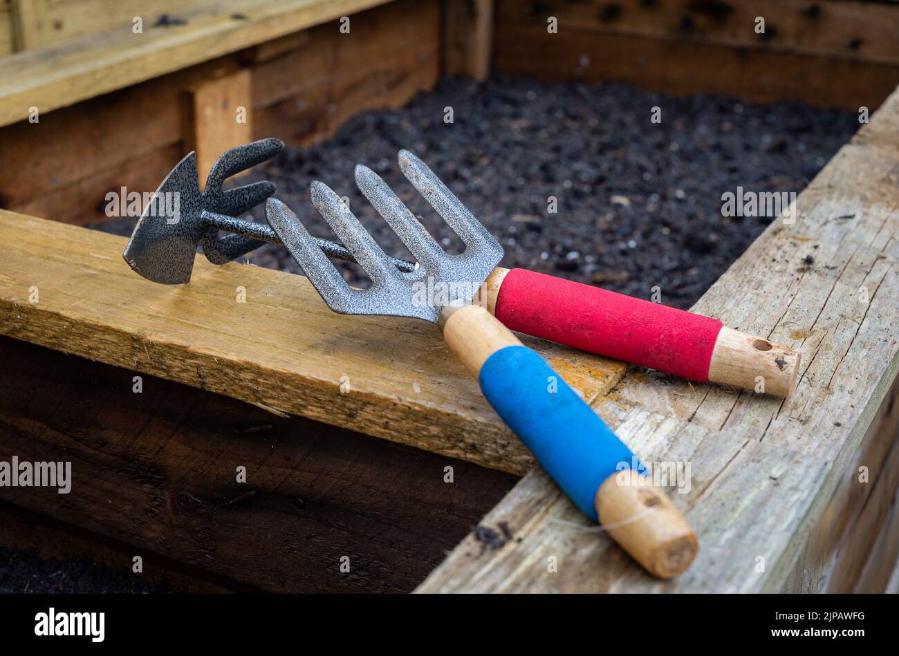 Weed fork and double sided hoe and rake garden hand tools on top of ...