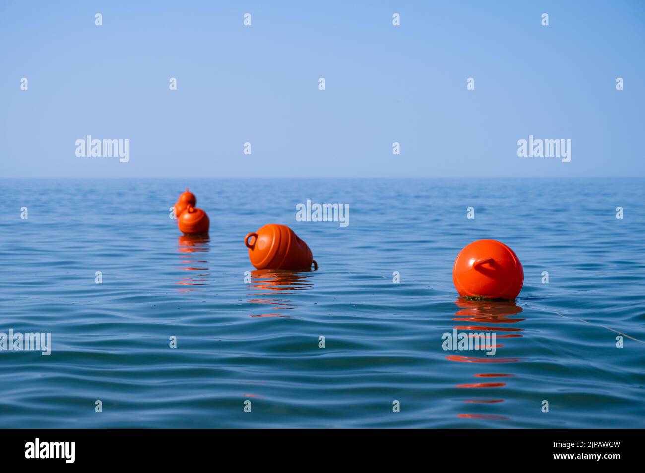 Orange floating buoys in the sea. Human life saving concept. Blue sky ...