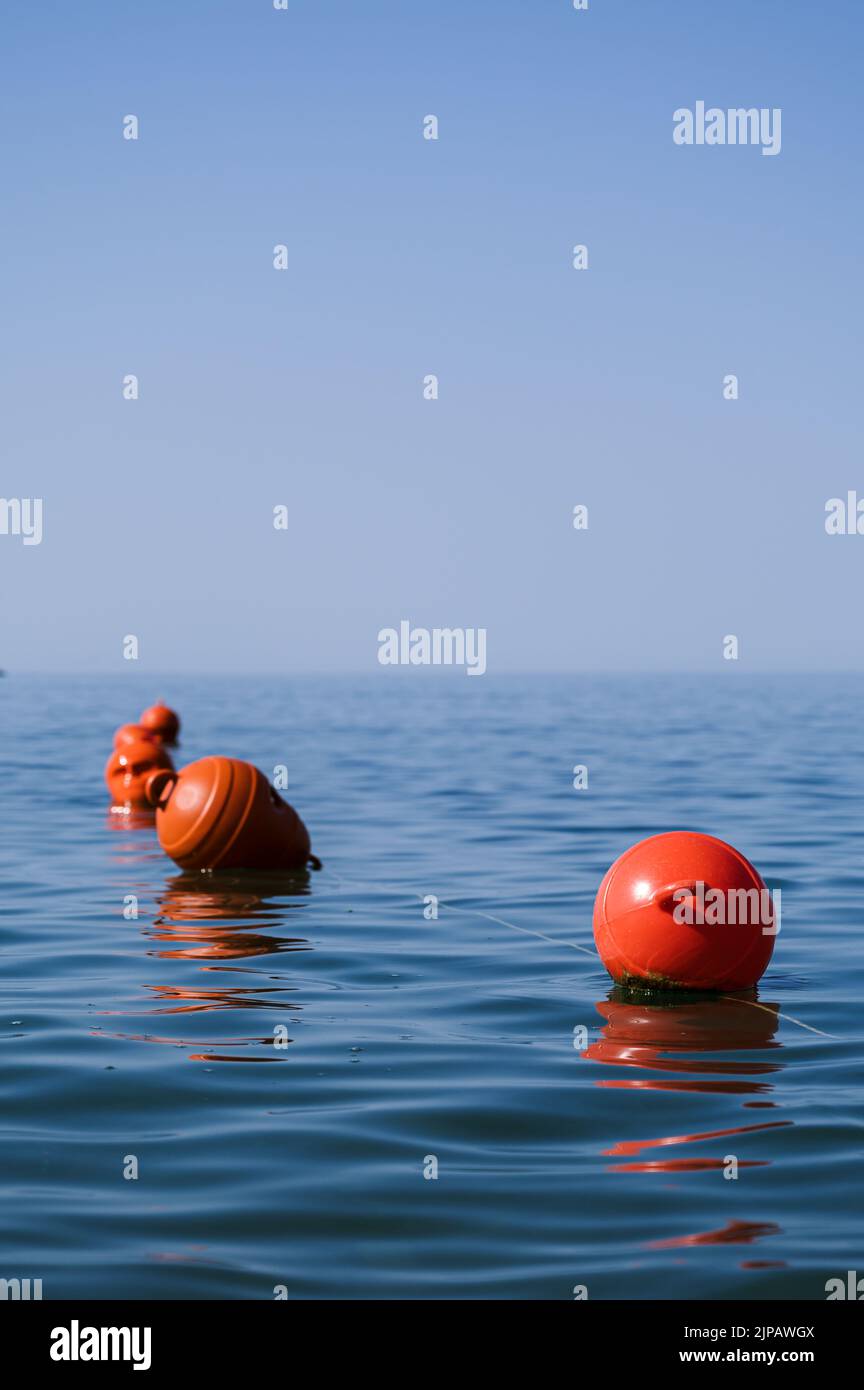 Orange floating buoys in the sea. Human life saving concept. Blue sky ...
