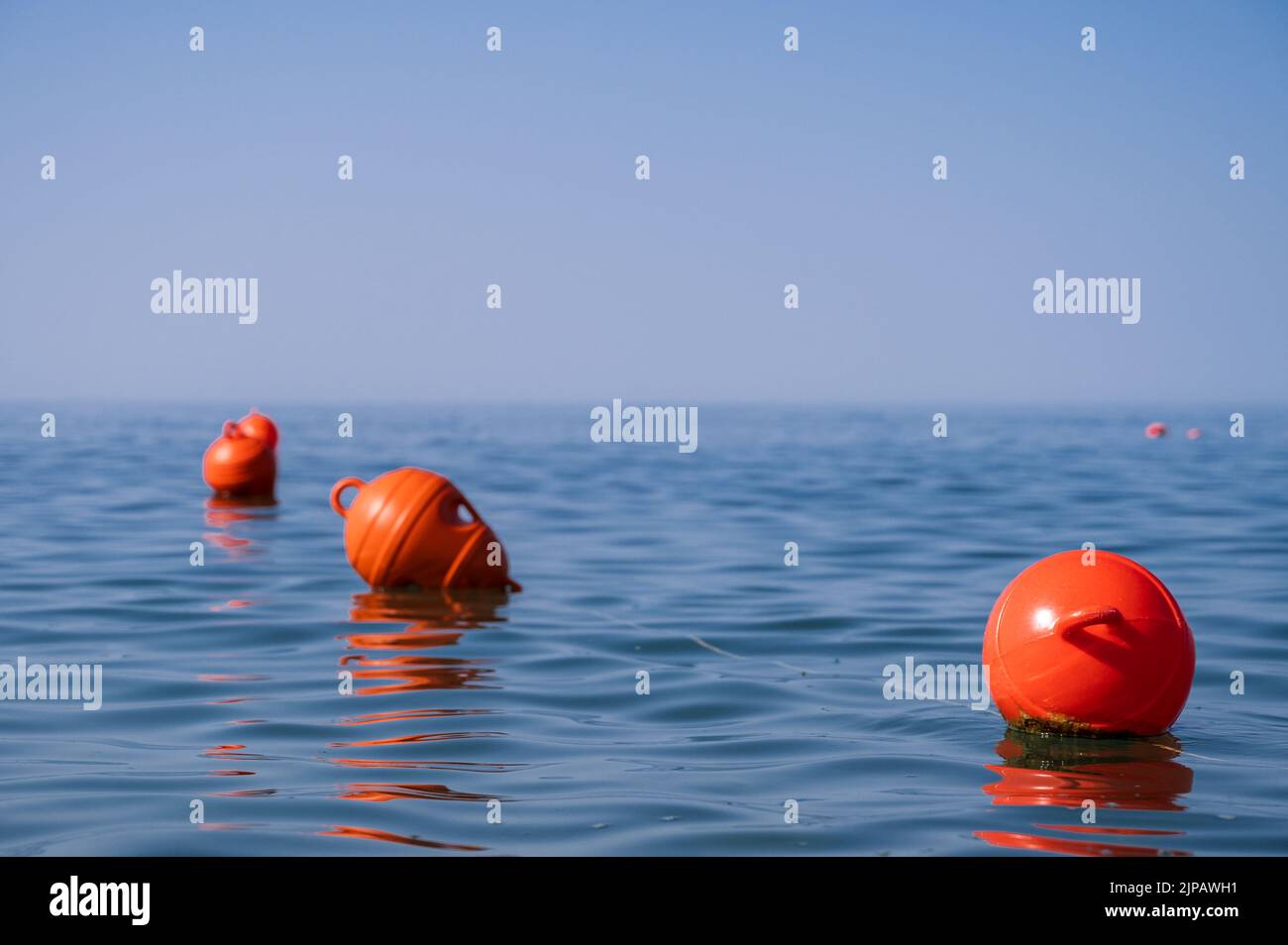 Orange floating buoys in the sea. Human life saving concept. Blue sky ...