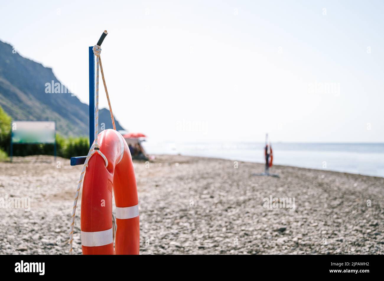 Orange life preserver on a pebble beach. Safety of people on the water ...