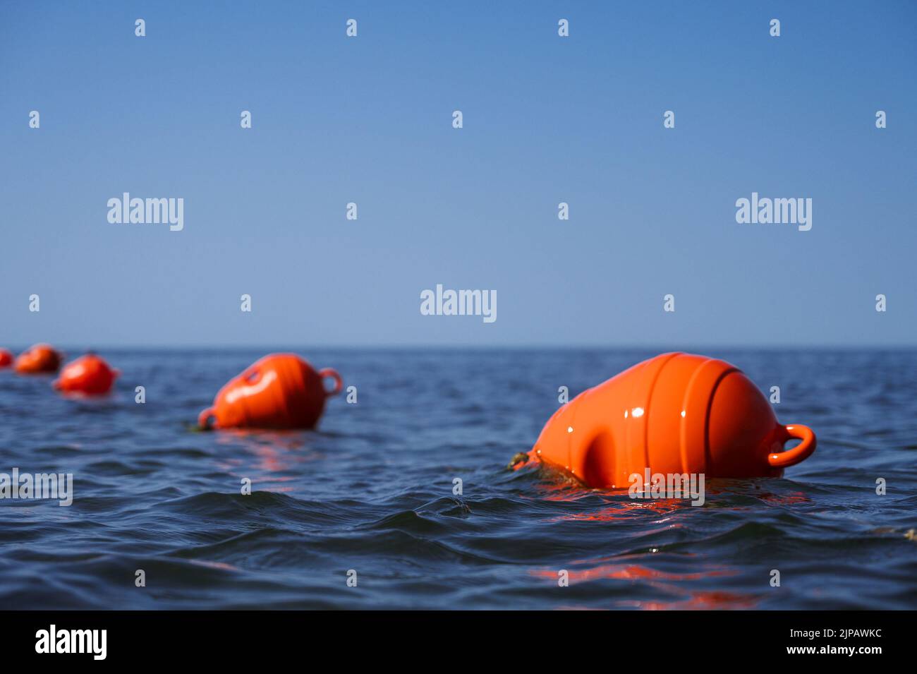 Orange floating buoys in the sea. Human life saving concept. Blue sky ...