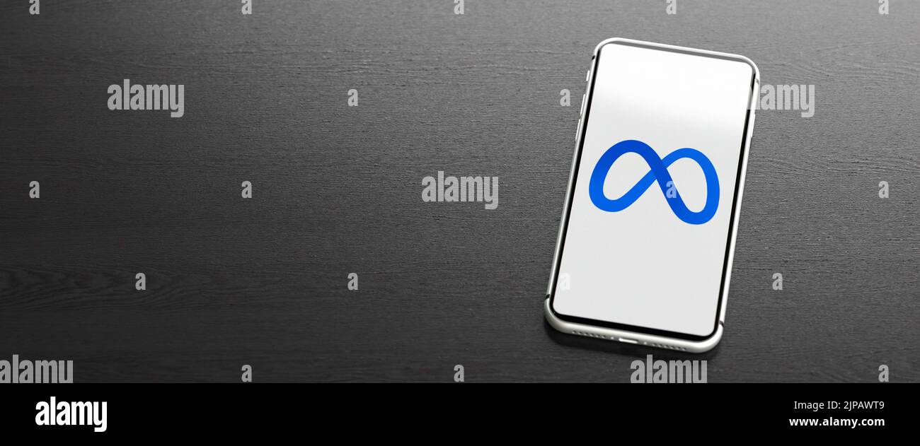 Logo of the facebook mother company Meta on a mobile phone on a table ...