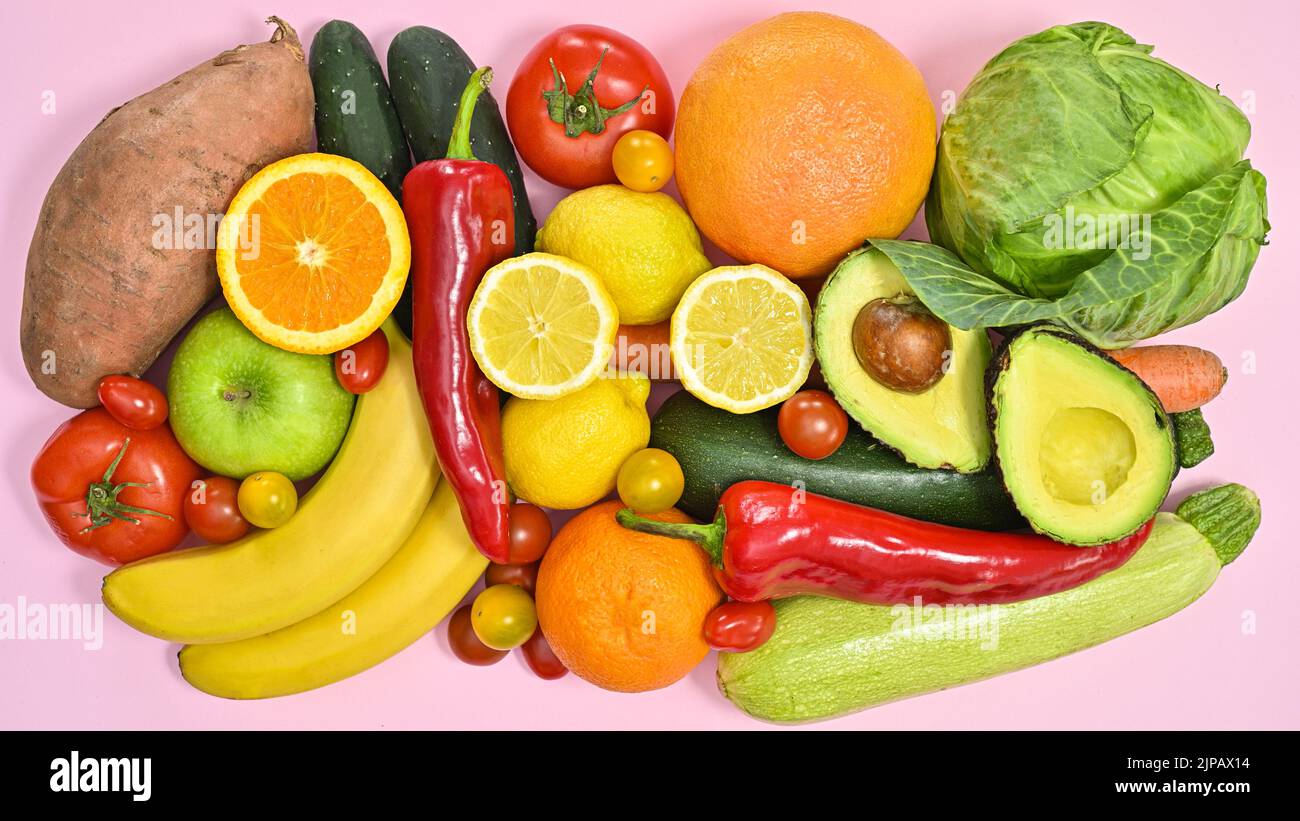 Creative layout with healthy fruits and vegetables on pastel pink ...