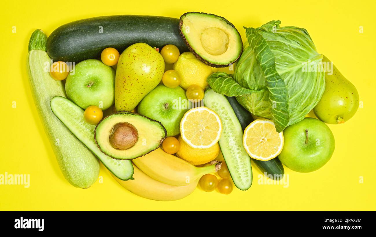 Creative layout of green and yellow fruits and vegetables on yellow ...