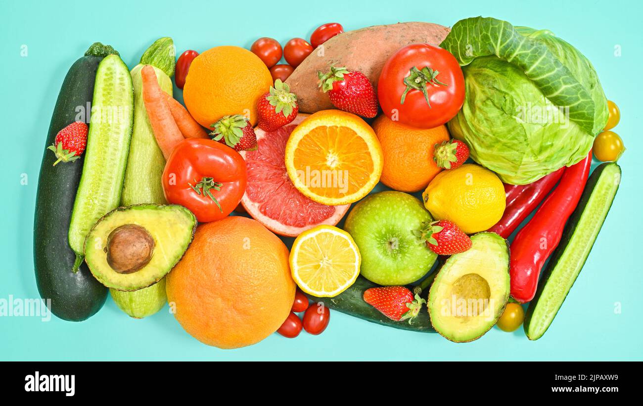 Ripe fresh fruits and vegetables arrangement on pastel cyan background ...