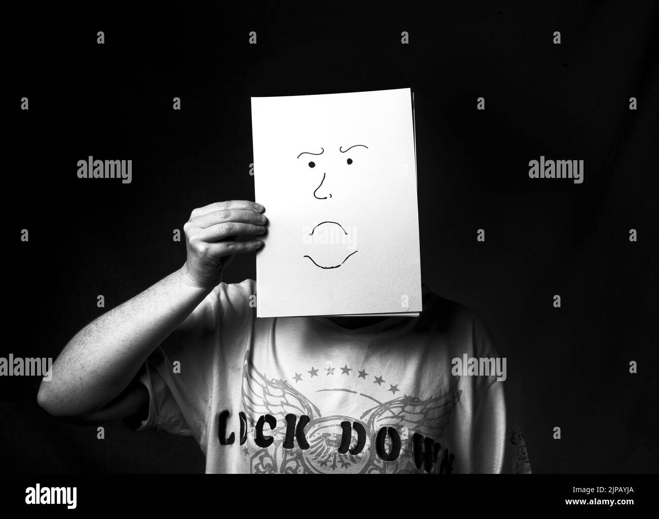 A grayscale of person holding paper with unhappy face drawing Stock ...