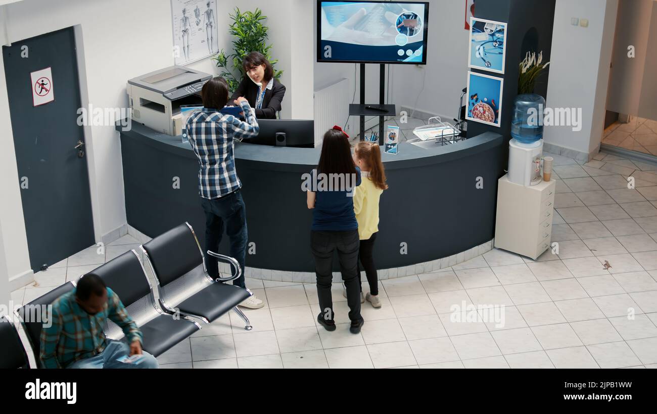 Busy hospital reception and waiting area with diverse patients, having ...