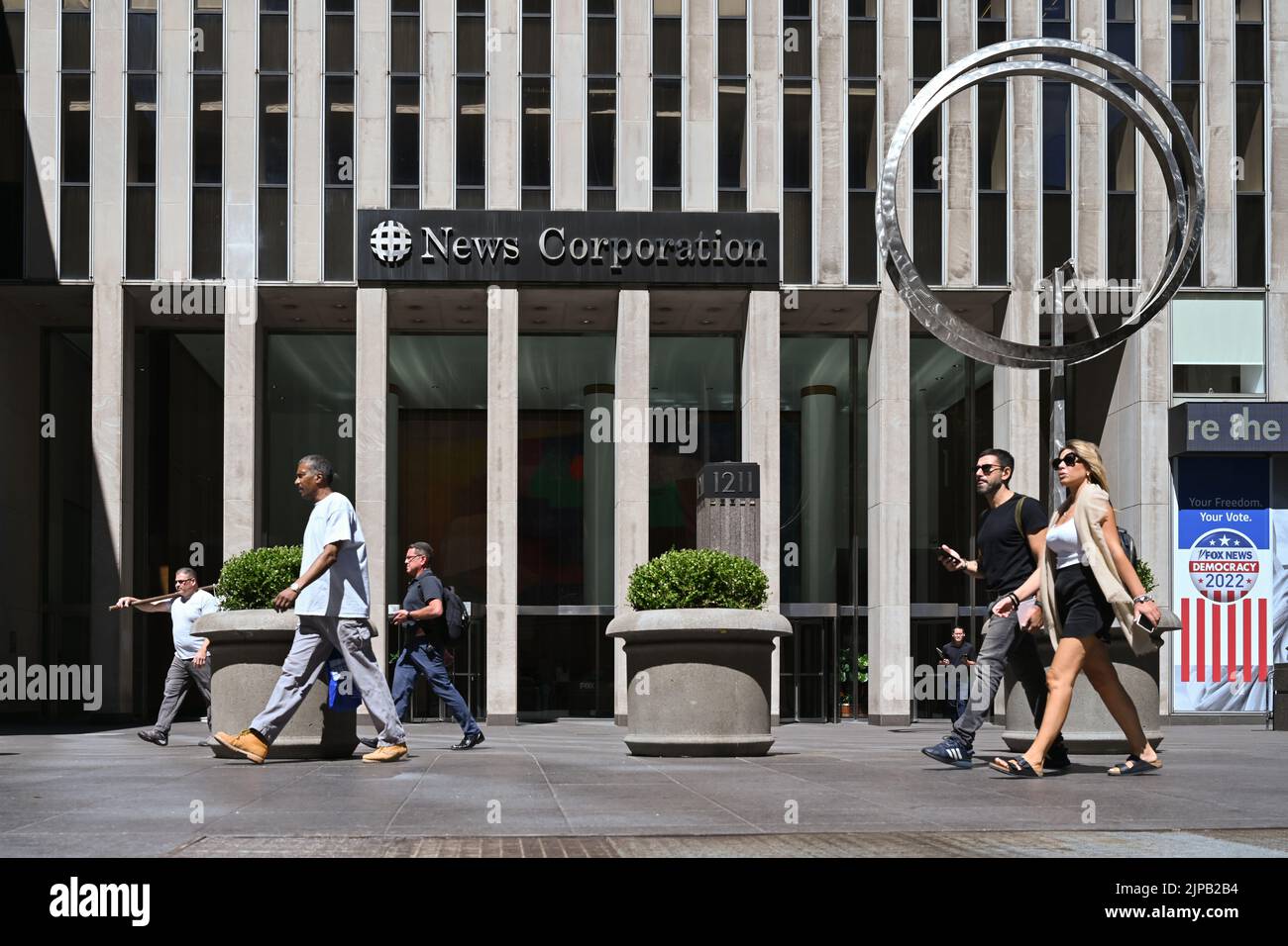 People walk past the News Corporation building, parent company of Fox ...