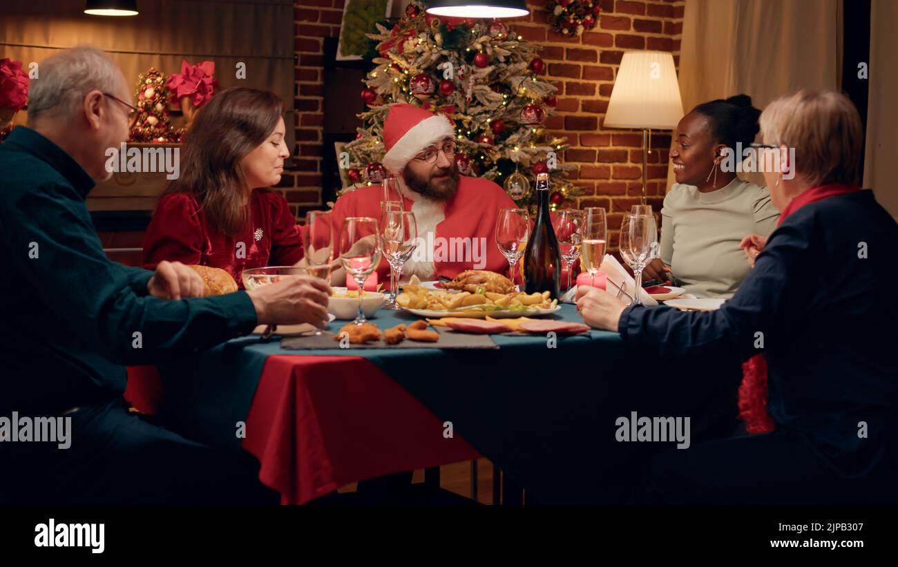 Funny husband wearing Santa Claus costume offering gifts to family ...