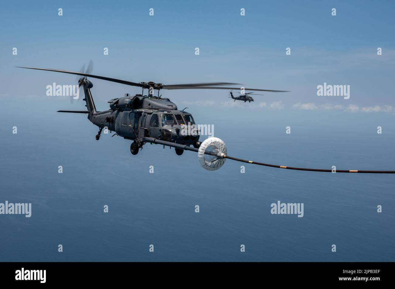 A HH-60G Pave Hawk Helicopter is refueled by a 39th Rescue Squadron HC ...