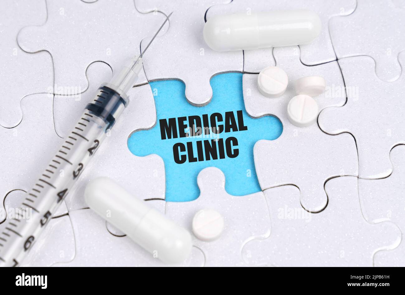 Medicine concept. There are pills and a syringe on the white puzzles ...