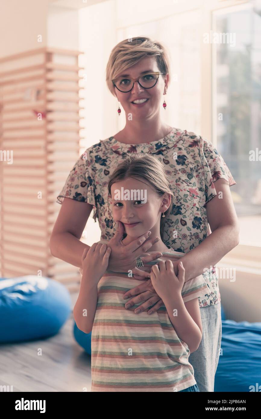 Portrait of a mother and daughter in a modern institution for preschool ...