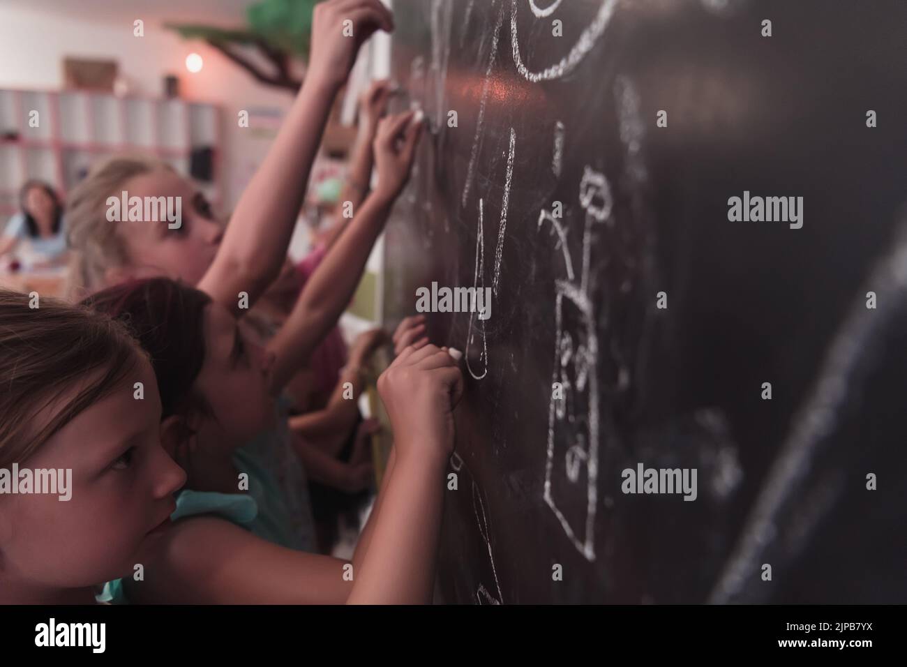 Children write and draw on the blackboard in elementary school while ...