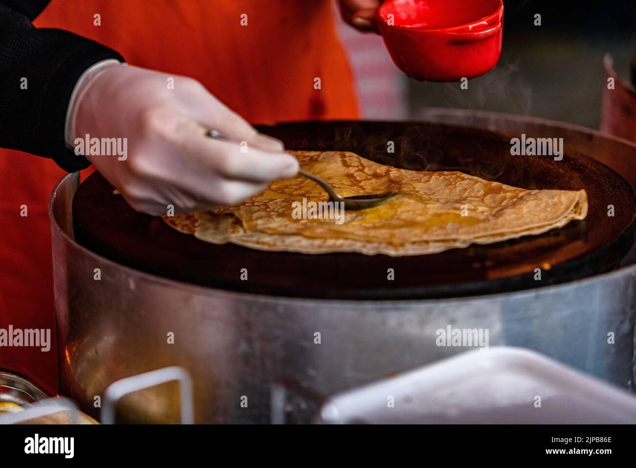 A closeup of the hands preparing a delicious puncake on the pan Stock ...