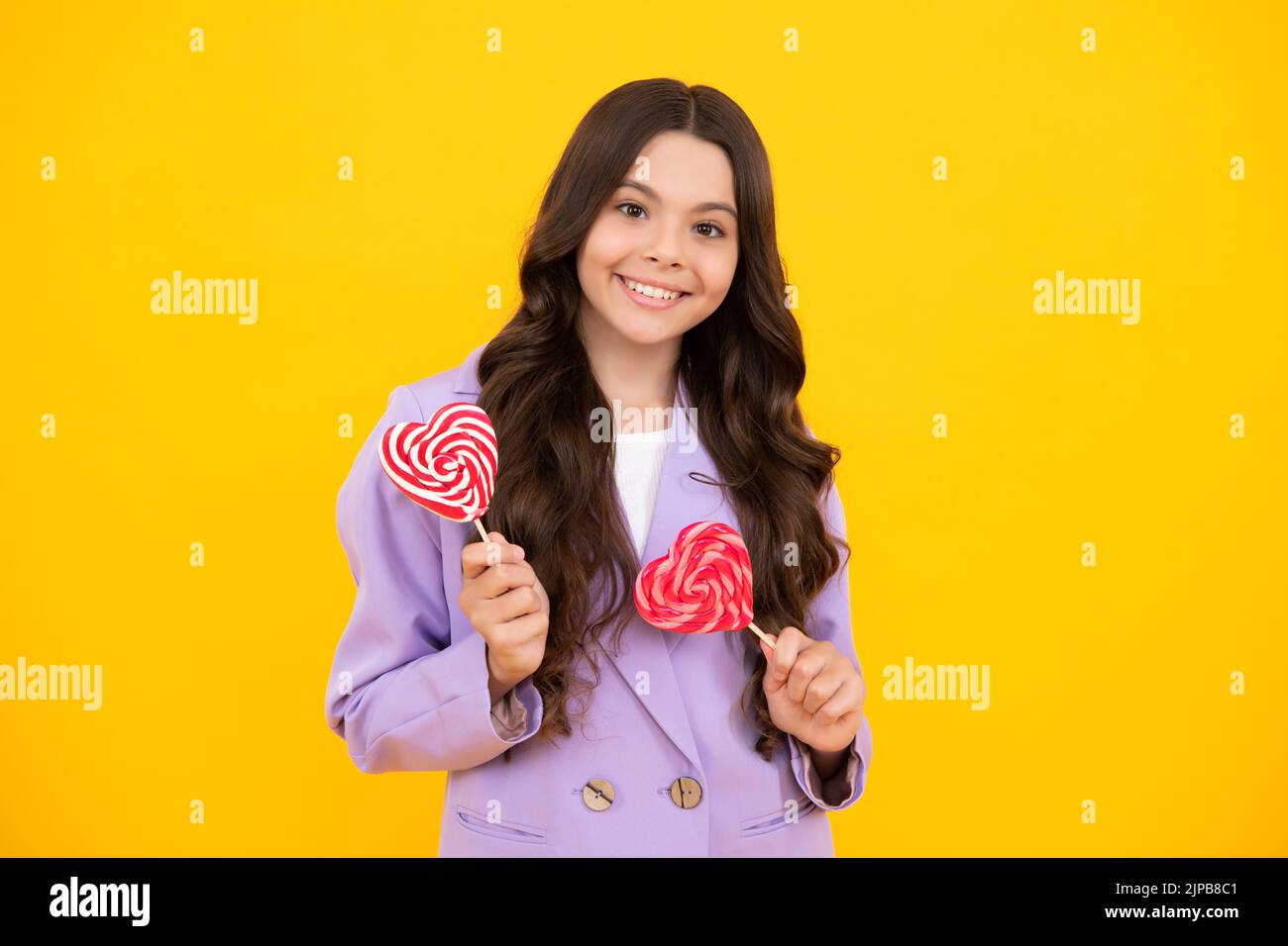 Cool teen child with lollipop over yellow isolated background. Sweet ...
