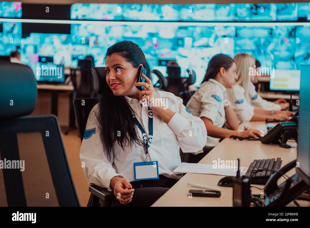 Female security guard operator talking on the phone while working at ...