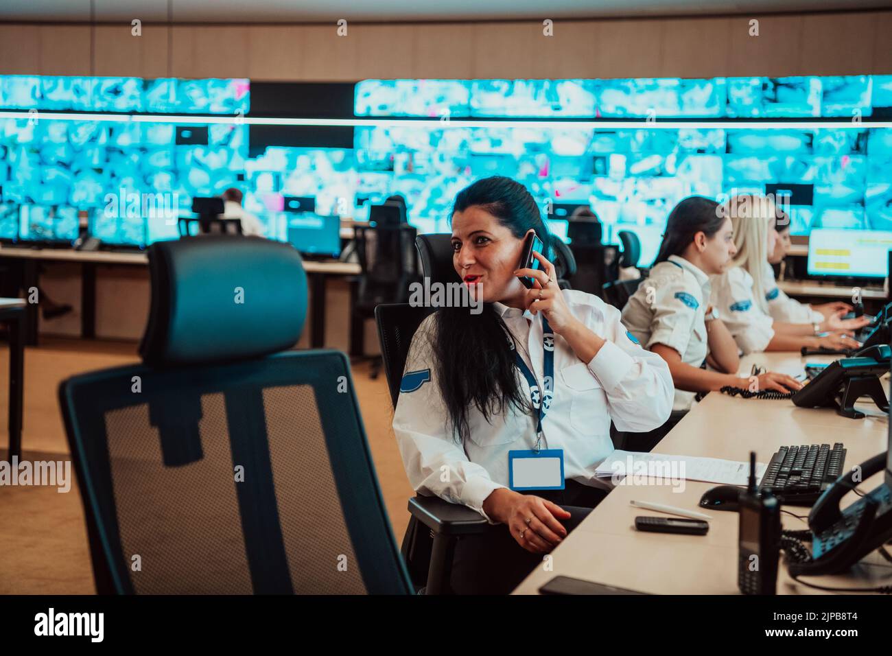 Female security guard operator talking on the phone while working at ...