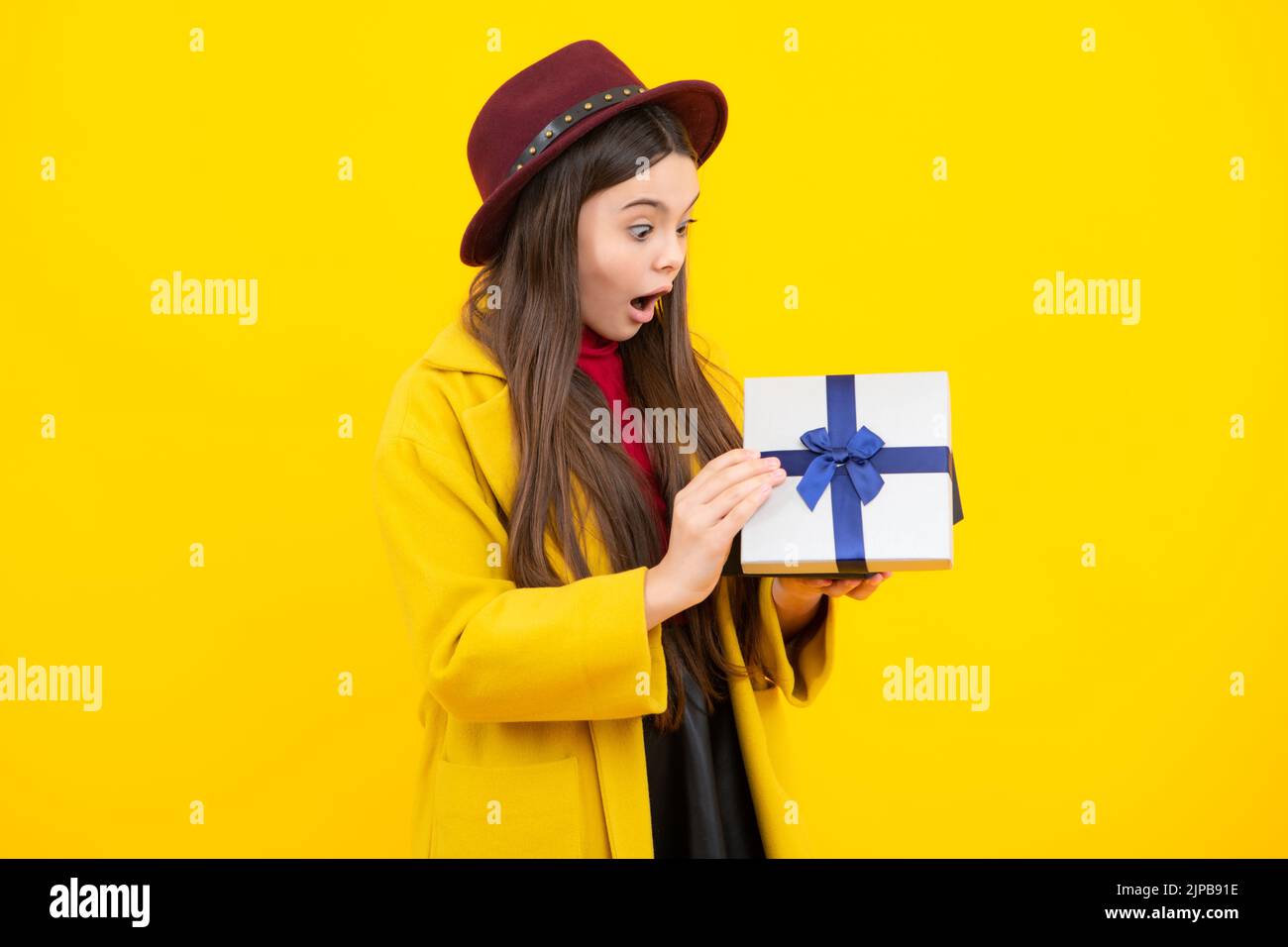 Child with gift present box on isolated studio background. Gifting for ...